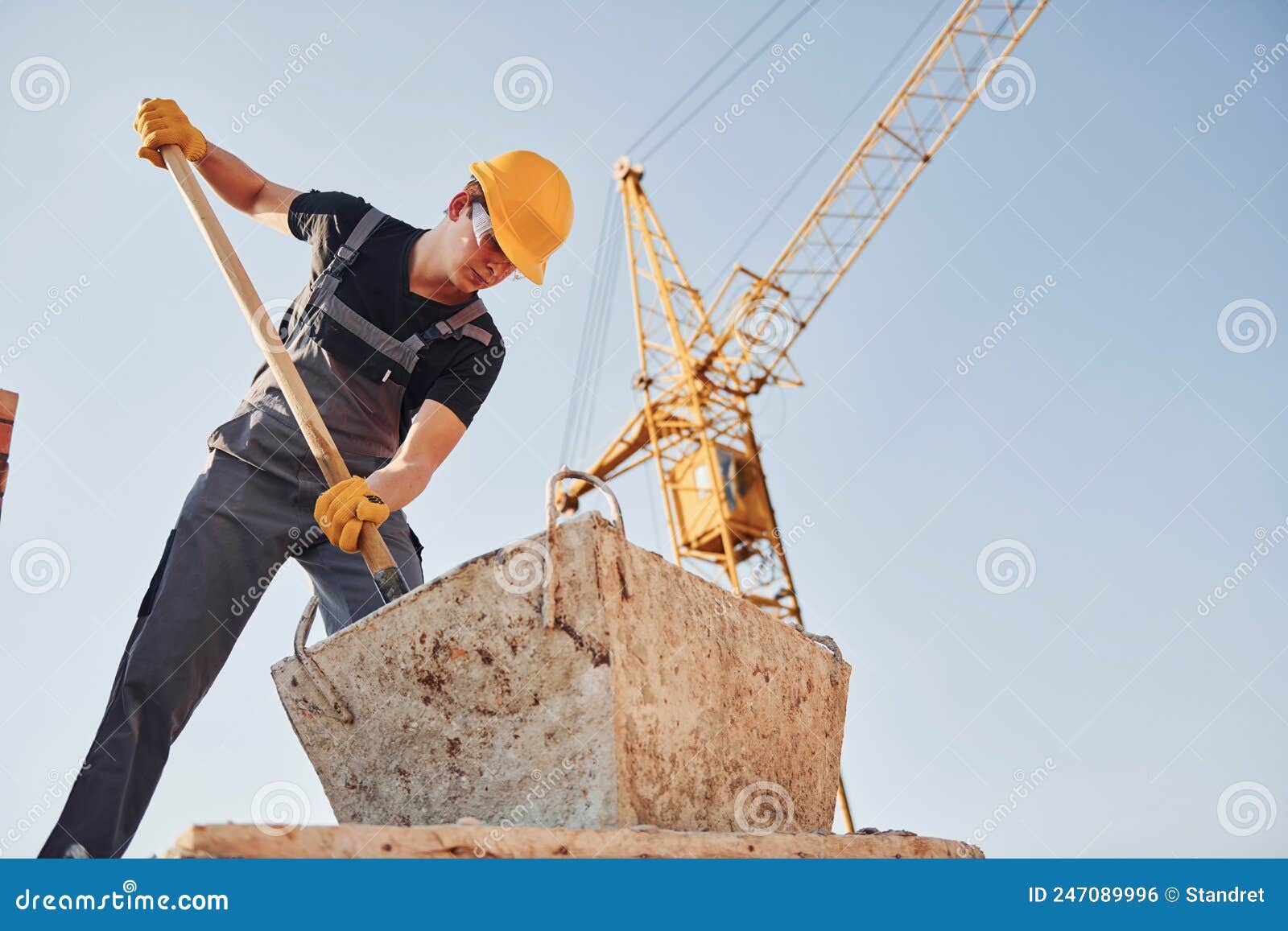 Using Showel. Construction Worker in Uniform and Safety Equipment Have ...