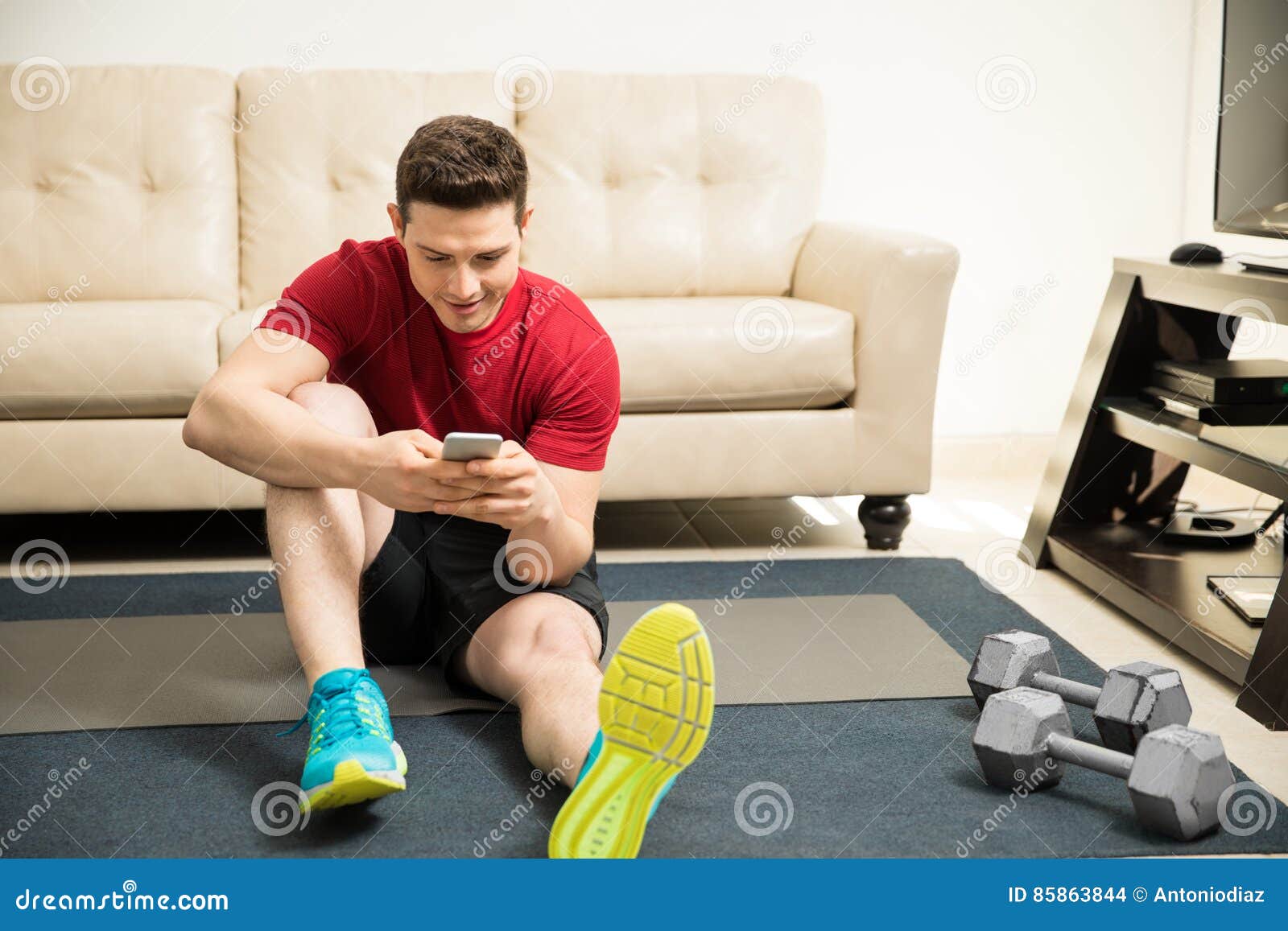 Using a Smartphone while Exercising Stock Photo - Image of male, home ...