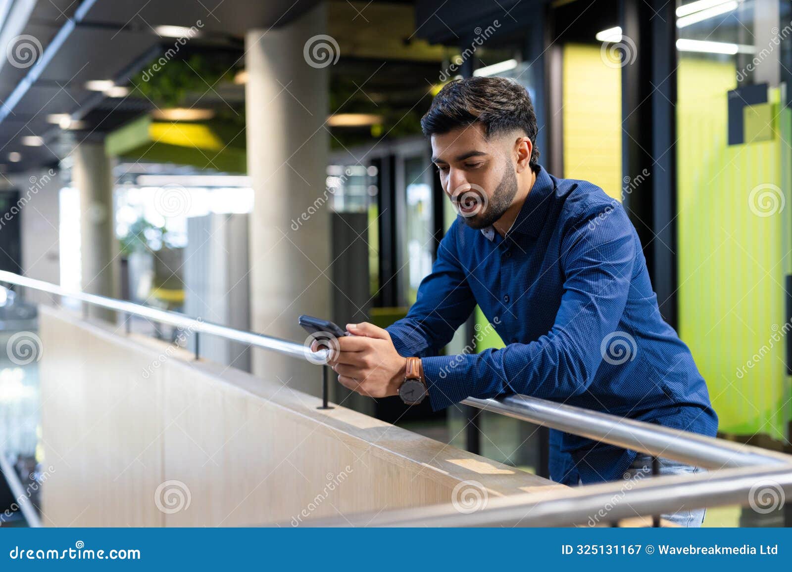 Using Smartphone, Man Leaning on Railing in Modern Office Building ...