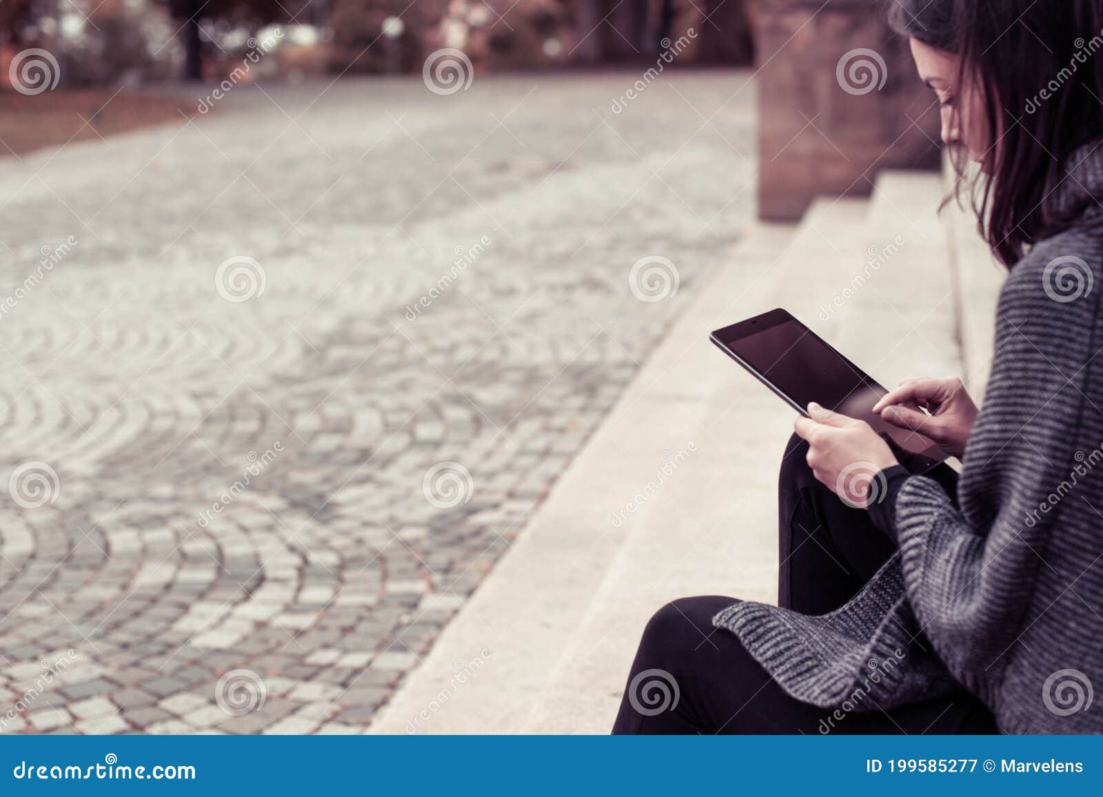 Using technology outdoors stock image. Image of sitting - 199585277
