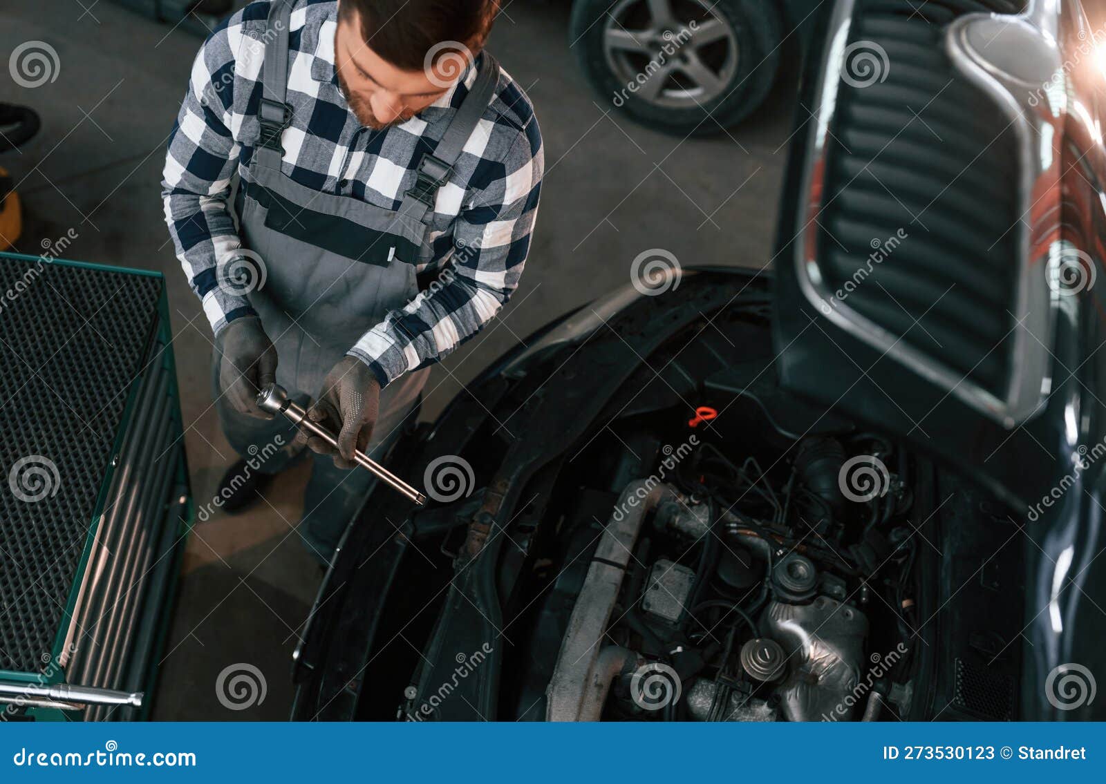 Using the Tool and Fixing the Car. Man in Uniform is Working in the ...