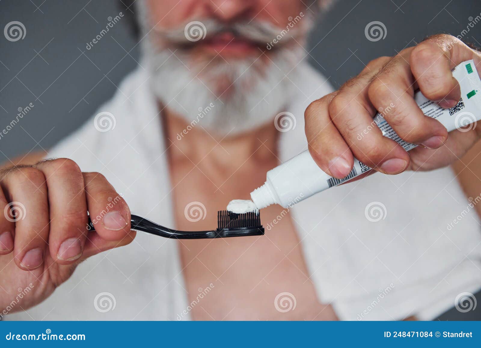 Using Toothpaste. Stylish Modern Senior Man with Gray Hair and Beard is ...