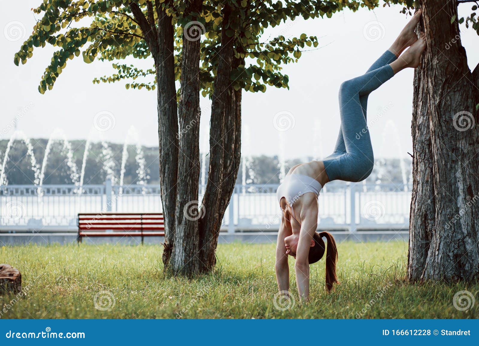 Using Tree To Keep Balance. Young Woman with Slim Type of Body Does ...