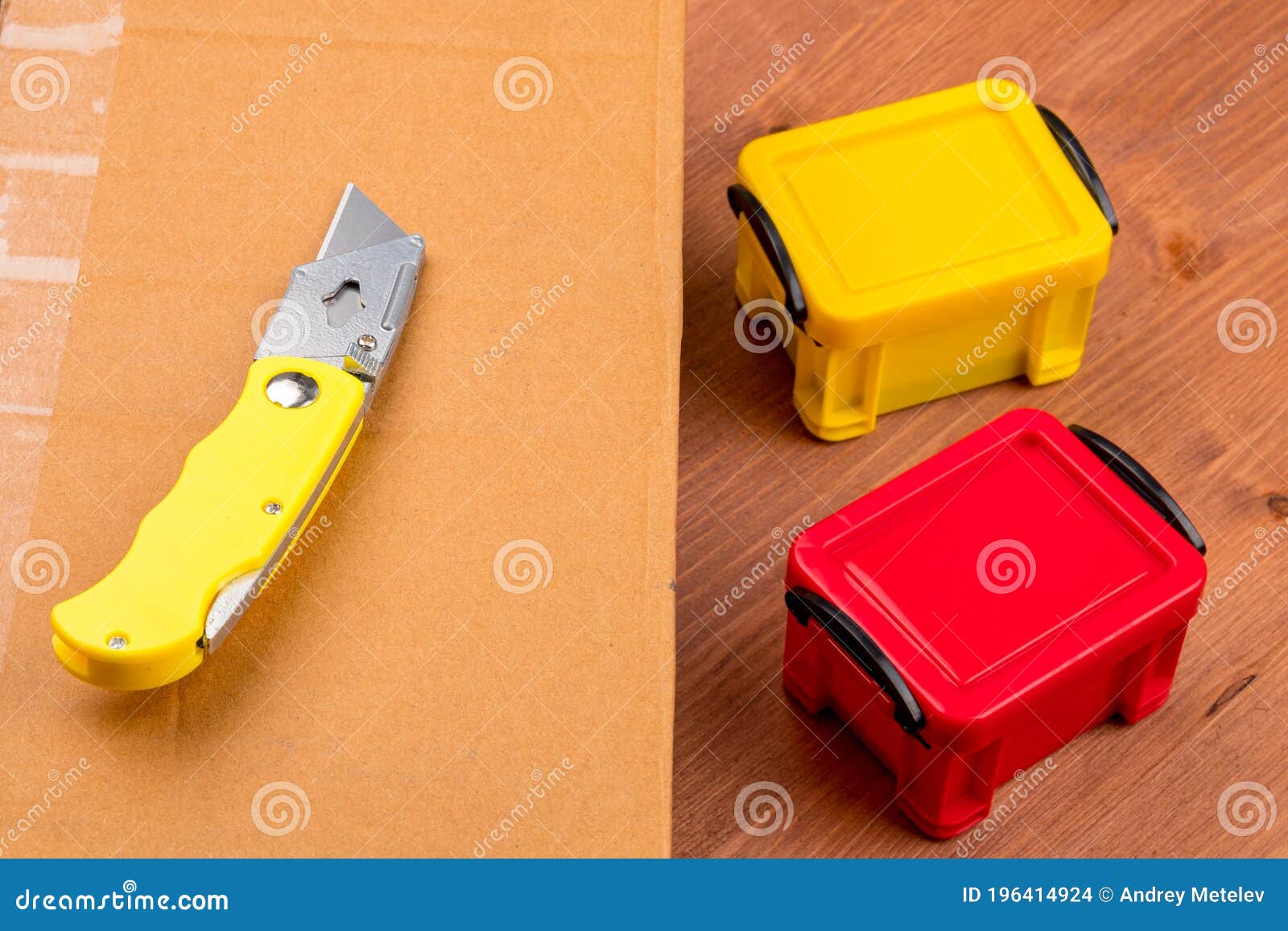 A Utility Knife on a Brown Box and Two Closed Containers Stock Photo ...