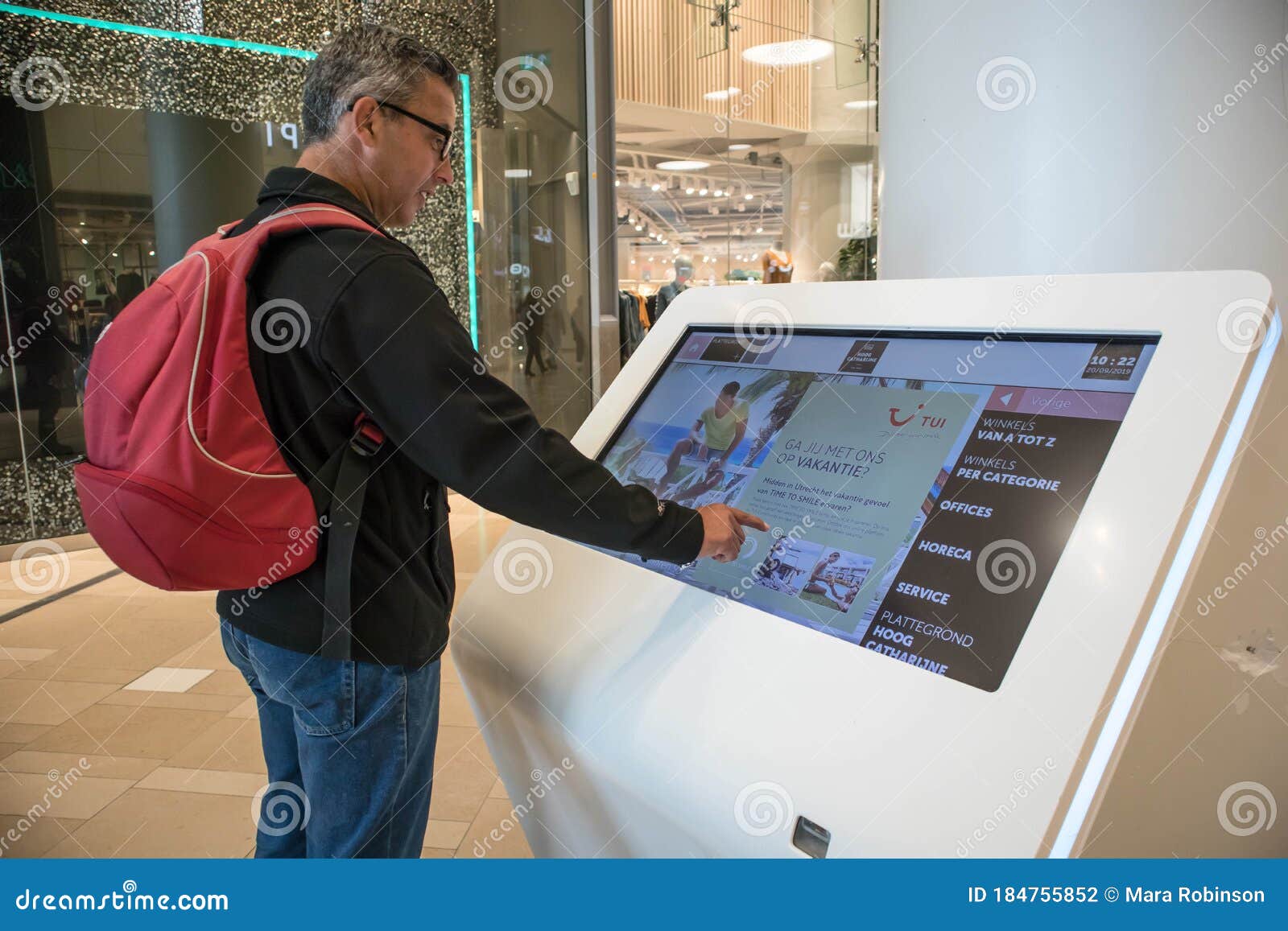 Man Using a Touch Screen Information Point in Inside a Shopping Mall ... Man Using a Touch Screen Information Point in Inside a Shopping Mall ...