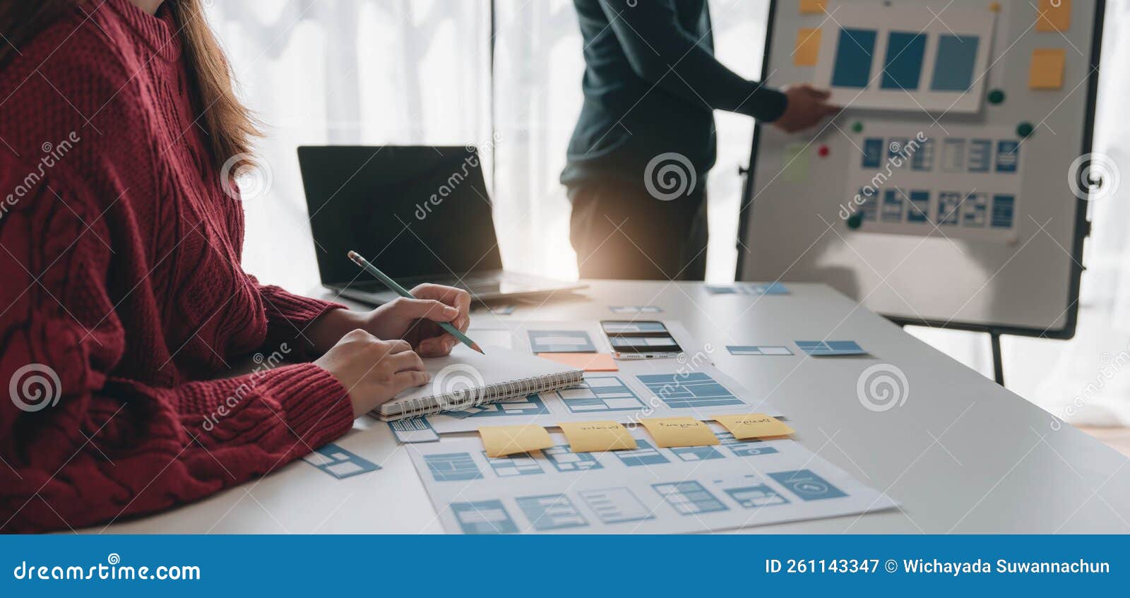 Ux Developer And Ui Designer Brainstorming About Mobile App Interface Wireframe Design On Table