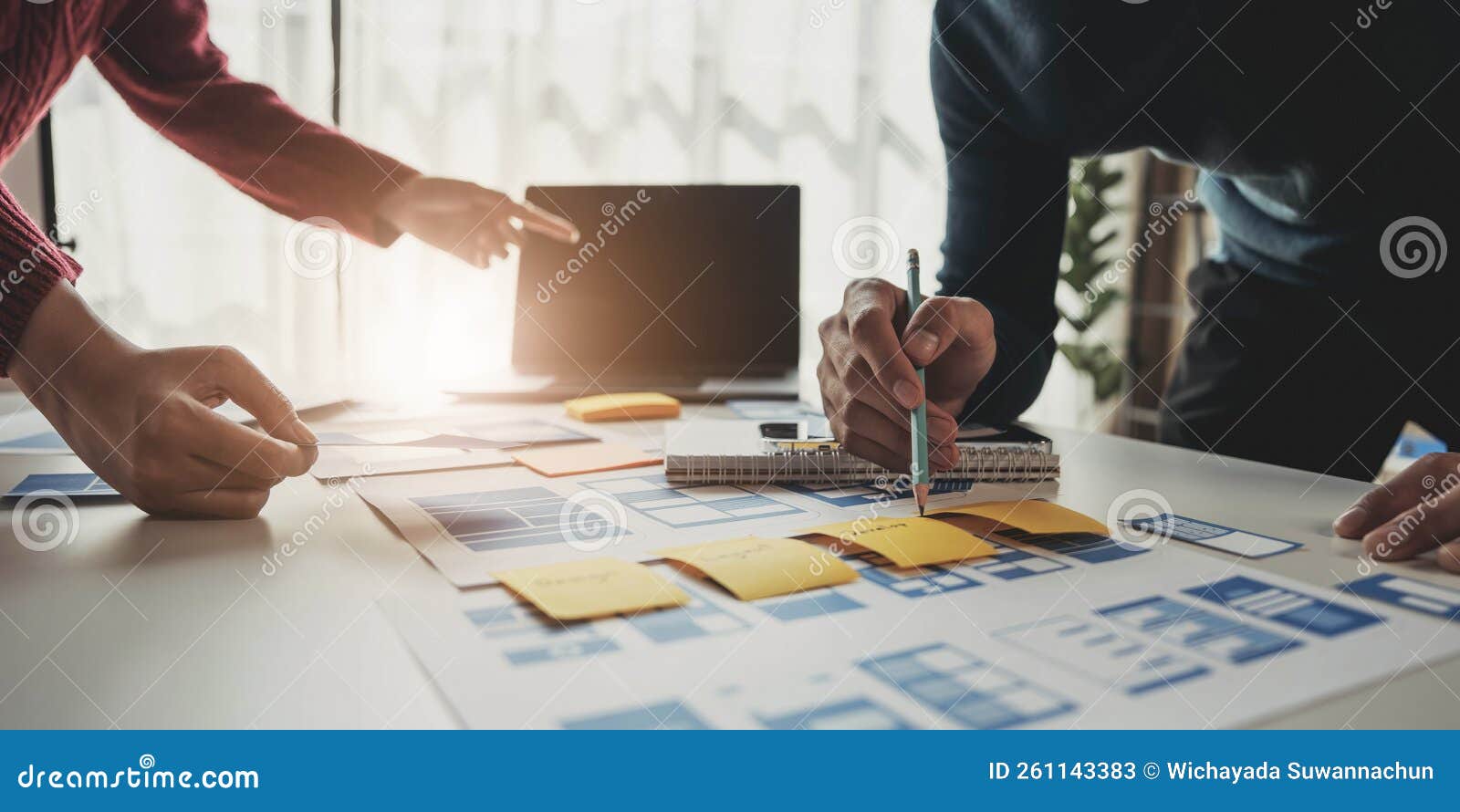 Ux Developer And Ui Designer Brainstorming About Mobile App Interface Wireframe Design On Table