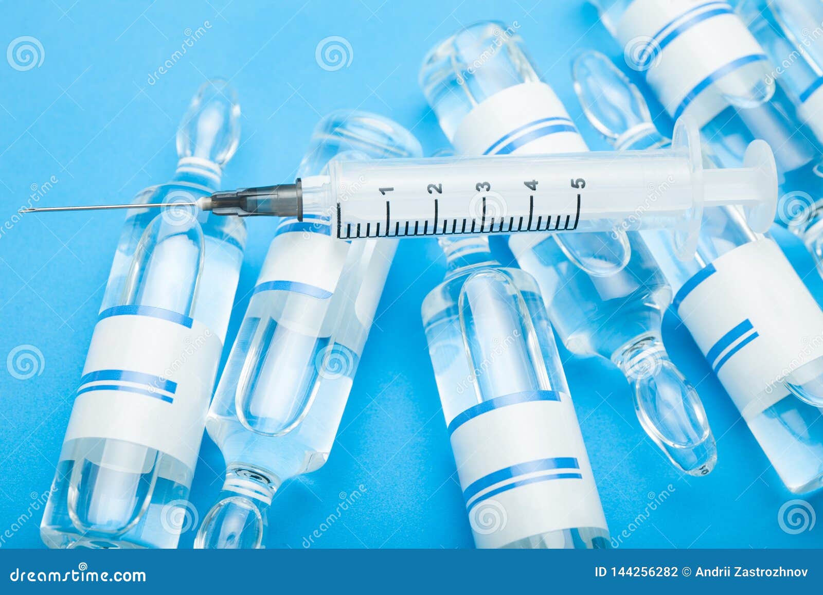 Vaccine Vials with Syringe on Blue Background Stock Photo - Image of ...