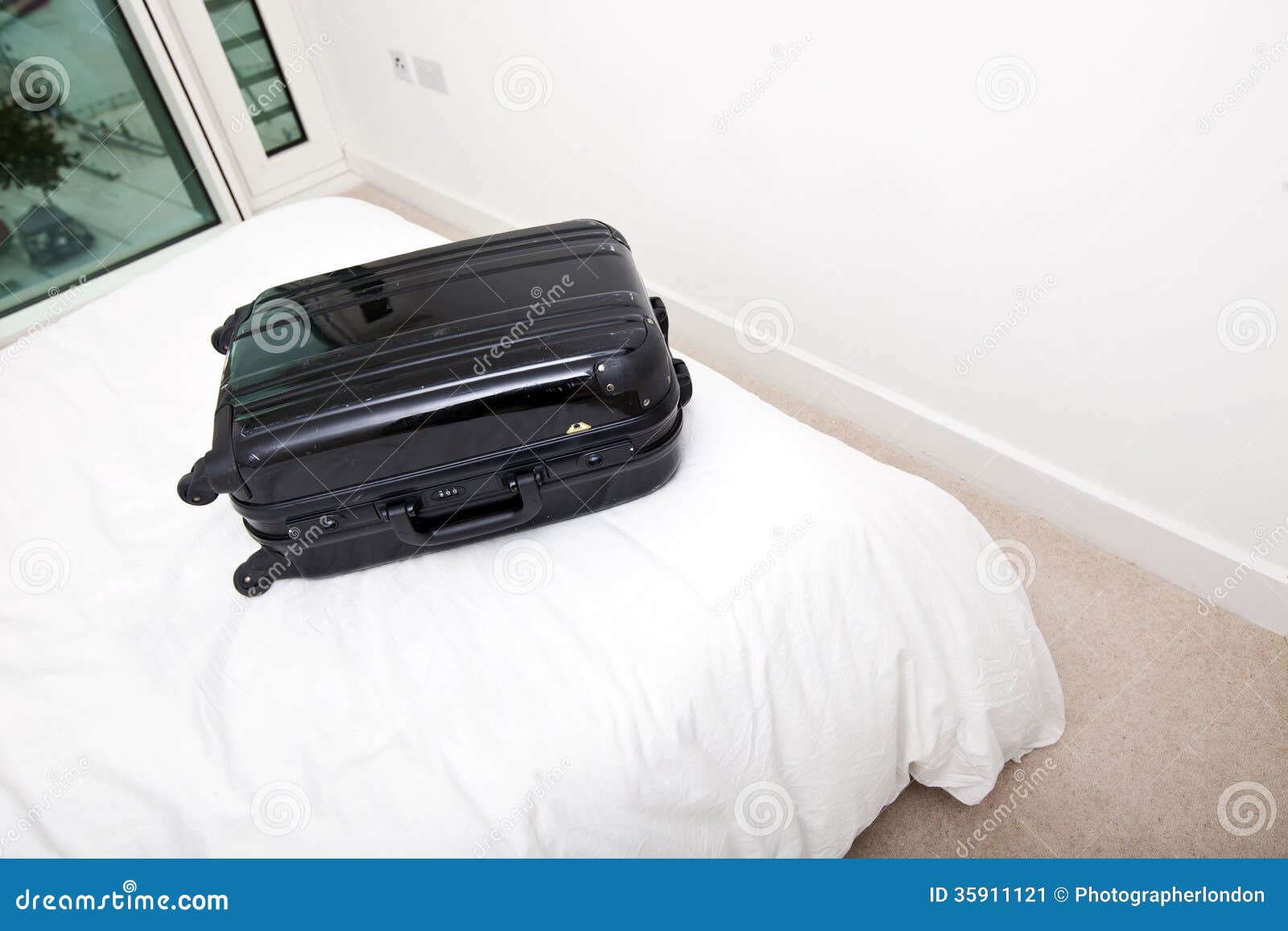 Valise noire sur le lit image stock. Image of préparation - 35911121