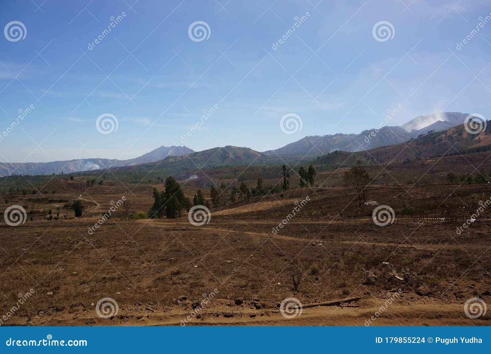 A Valley Surrounded by Mountains Stock Photo - Image of field, cloudy ...