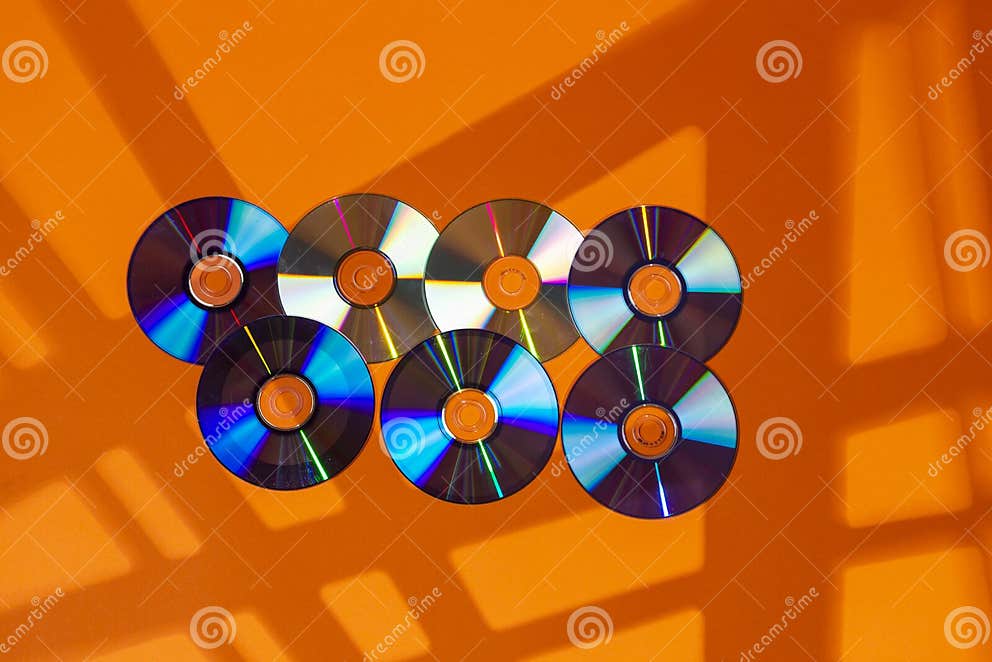Variety of Arranged CD Disks or DVD Disks on Orange Background with ...