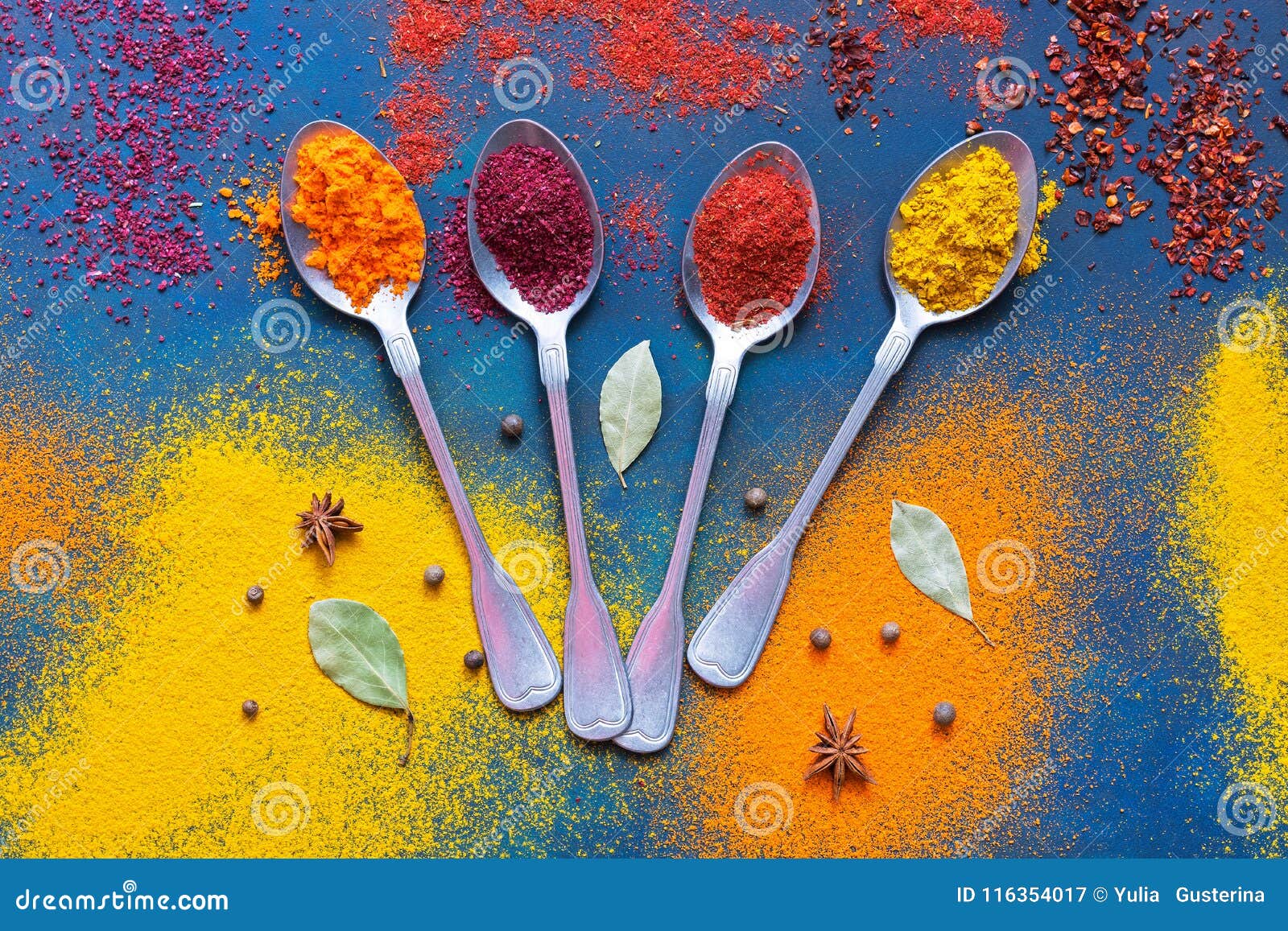 A Variety of Bright Spices with Spoons on a Blue Background. View from ...