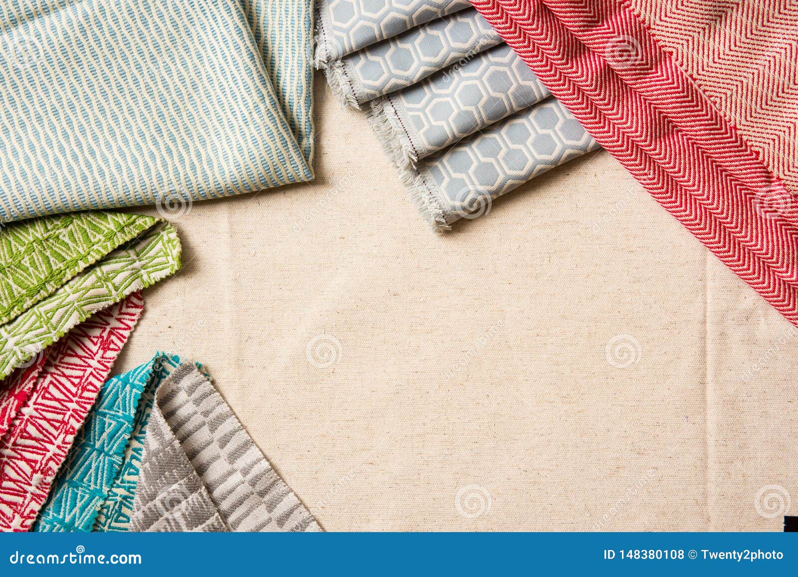 A Variety of Colourful Fabrics Folded and Layed Out Over a Canvas Table ...