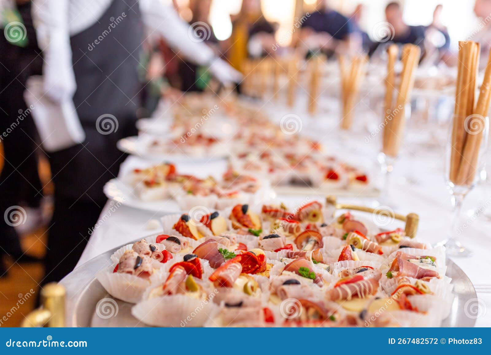 Various Canapes Appetizers Served on Buffet Table. Waiter in the ...