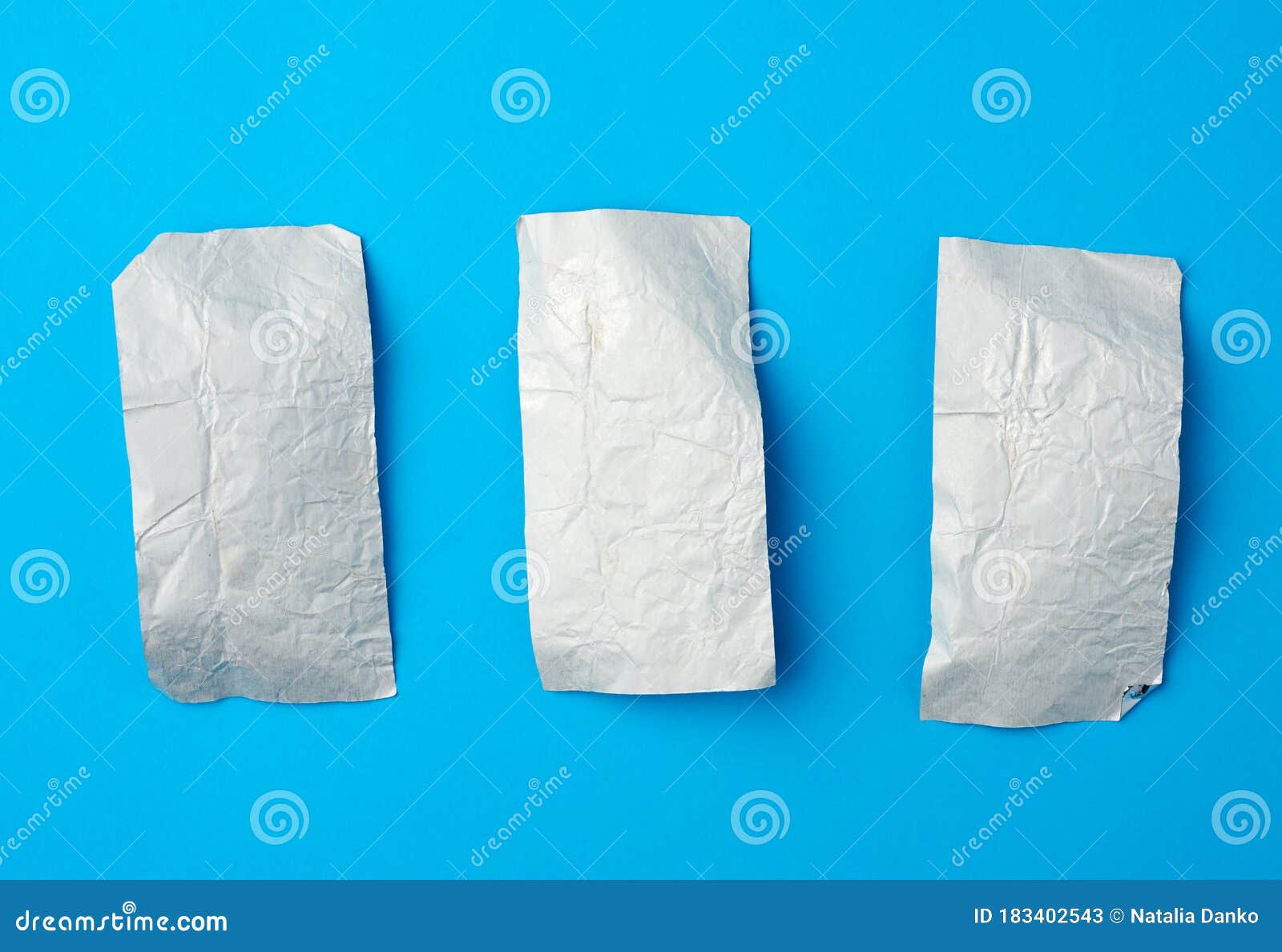 Various Crumpled Foil Used Candy Wrappers on a Blue Background Stock ...