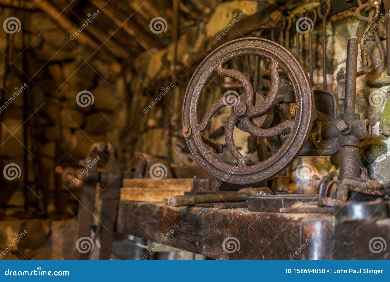 Various Rare and Vintage Metal Tools on a Work Bench. a Metal Wheel and ...