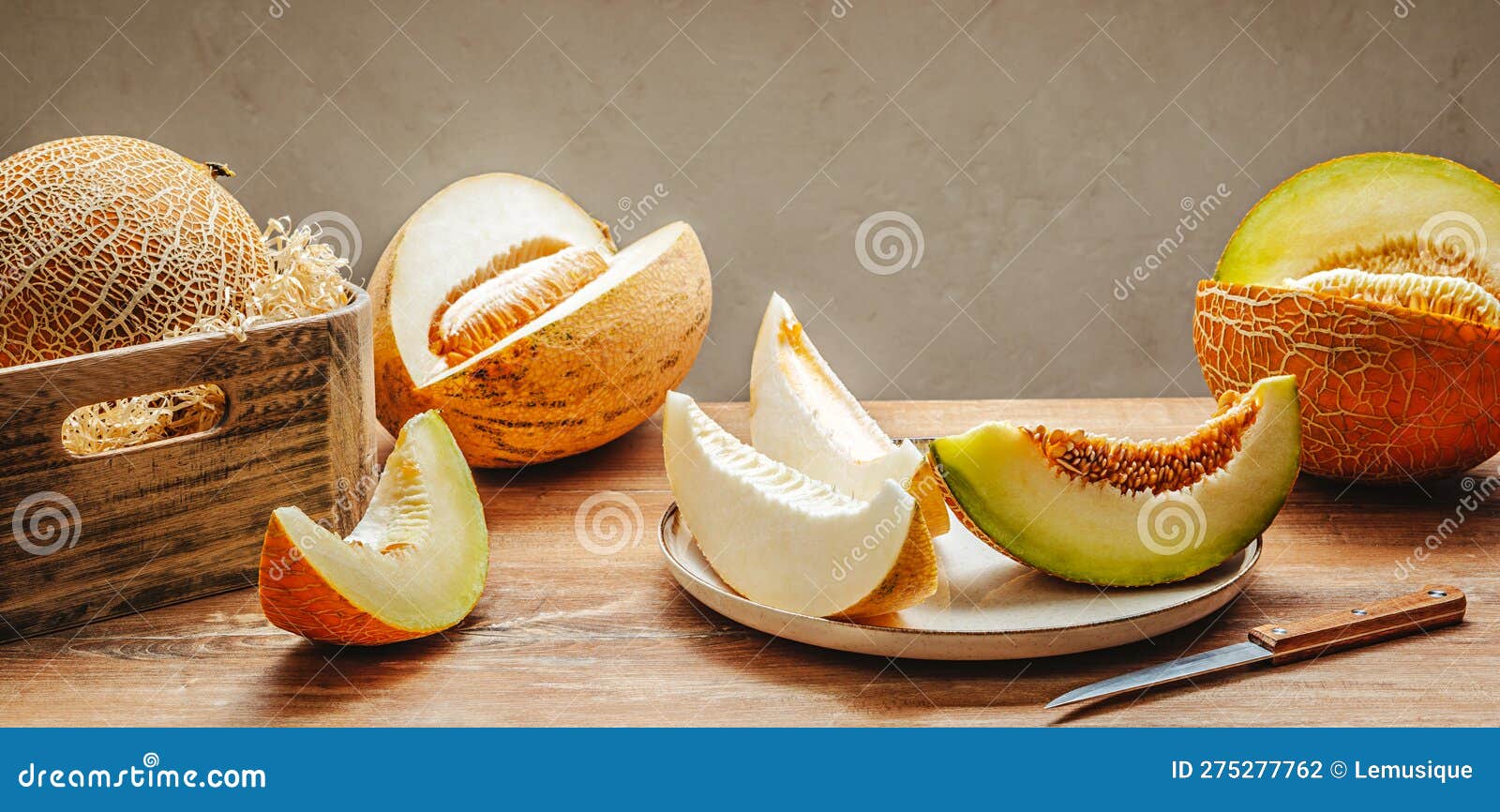 Various Sliced Melons on Wooden Table by Stone Wall Stock Photo - Image ...