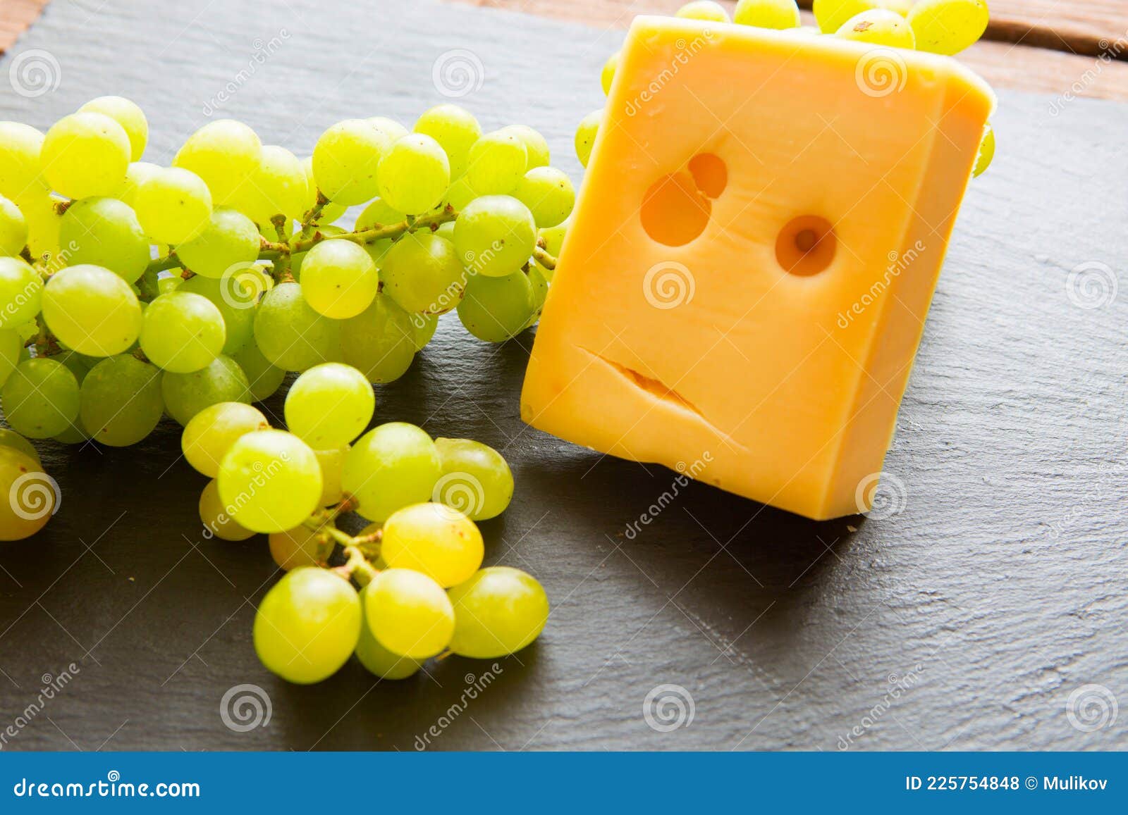 Various Types of Cheese with Green Grapes on Black Slate Cheeseboard on ...