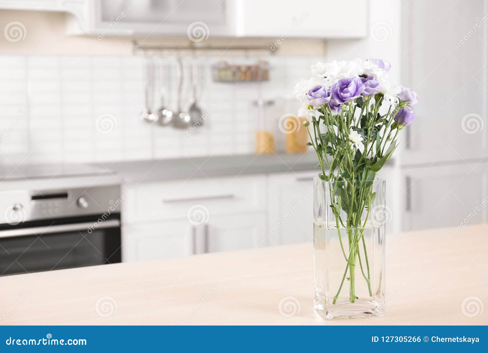 Vase with Beautiful Flowers on Table in Kitchen Interior Stock Photo ...