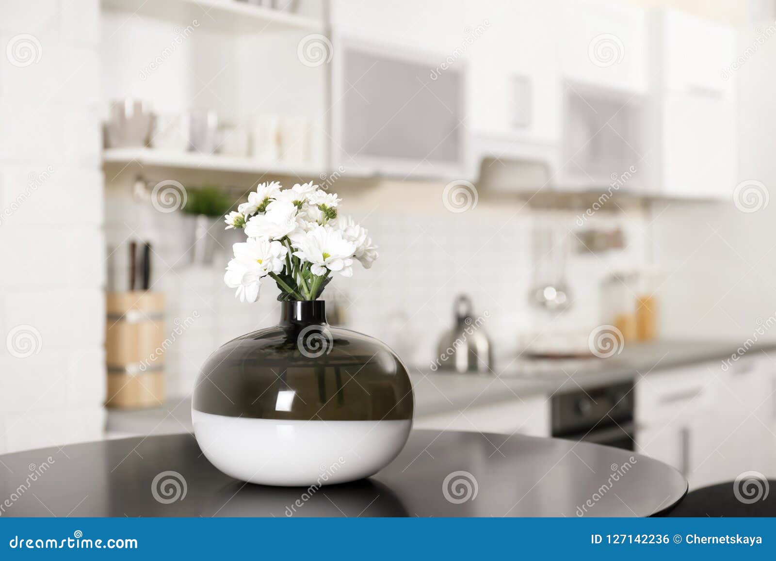 Vase with Beautiful Flowers on Table in Kitchen Interior. Stock Photo ...