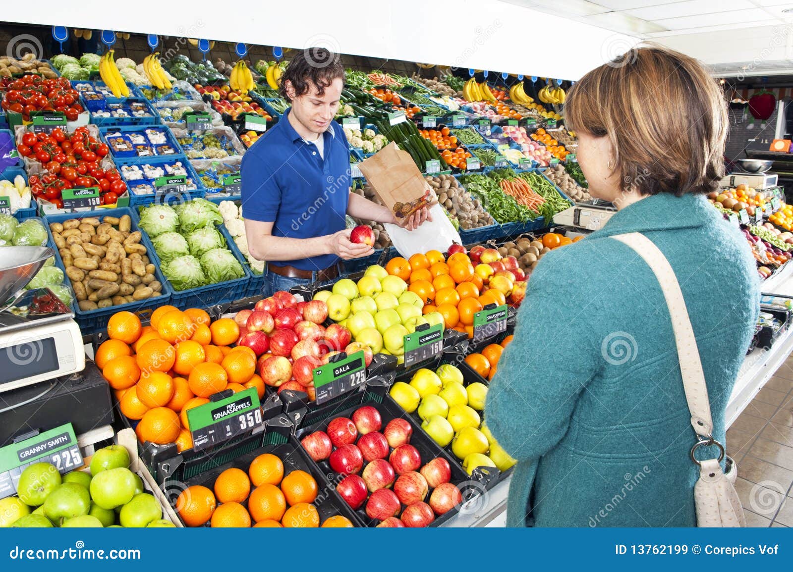 Verdulero Que Sirve a Un Cliente Imagen de archivo - Imagen de medio ...