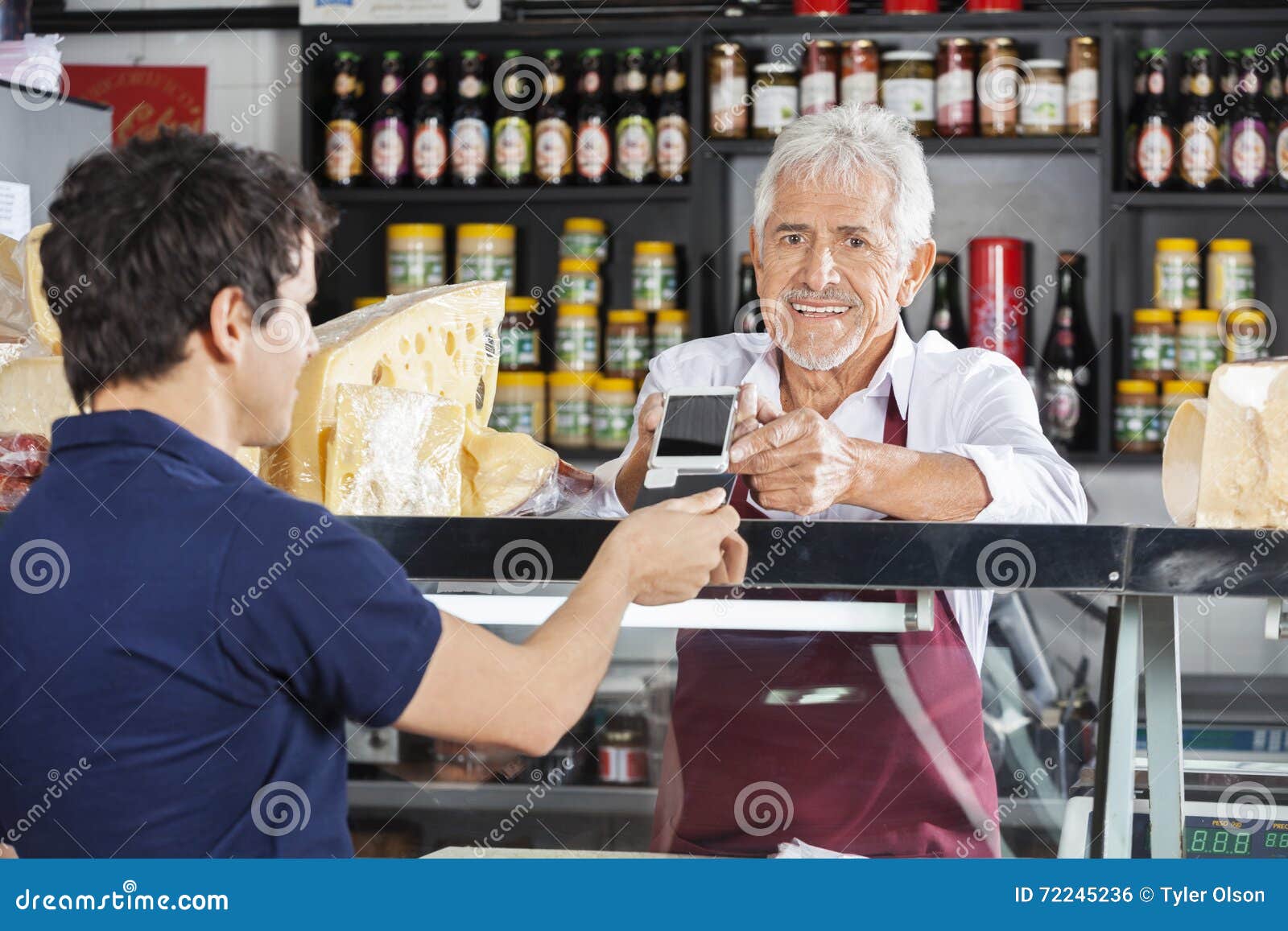 Verkoper Accepting Mobile Payment Van Klant in Kaaswinkel Stock Foto ...