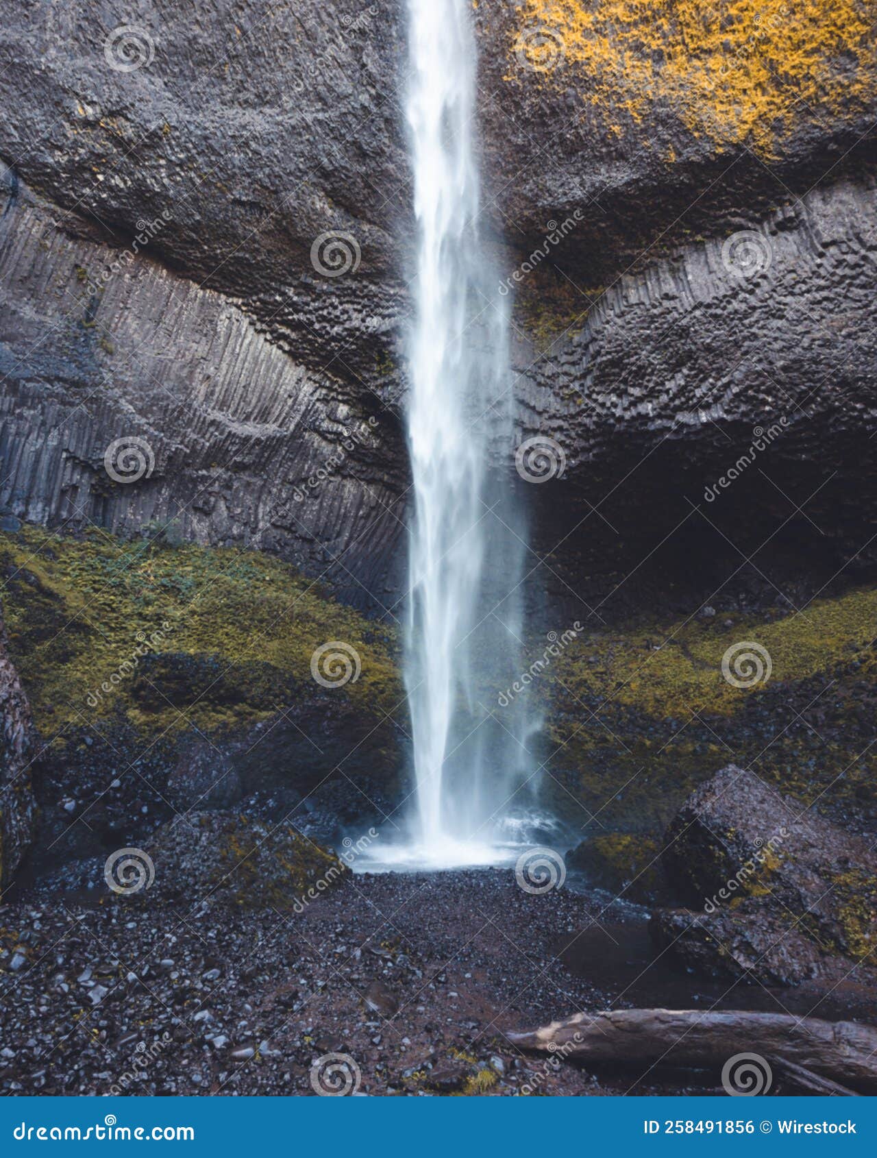 Vertica Shot of a Narrow Waterfall Flowing Over the Mossy Cliffs Stock ...