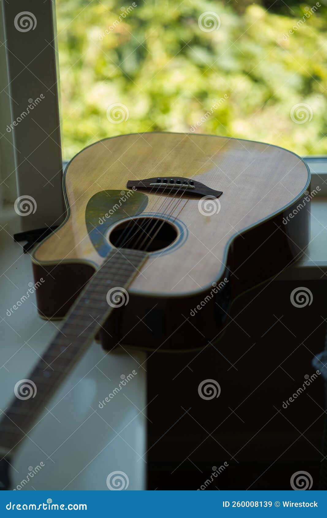 Vertical of an Acoustic Guitar on a Windowsill Stock Image - Image of ...