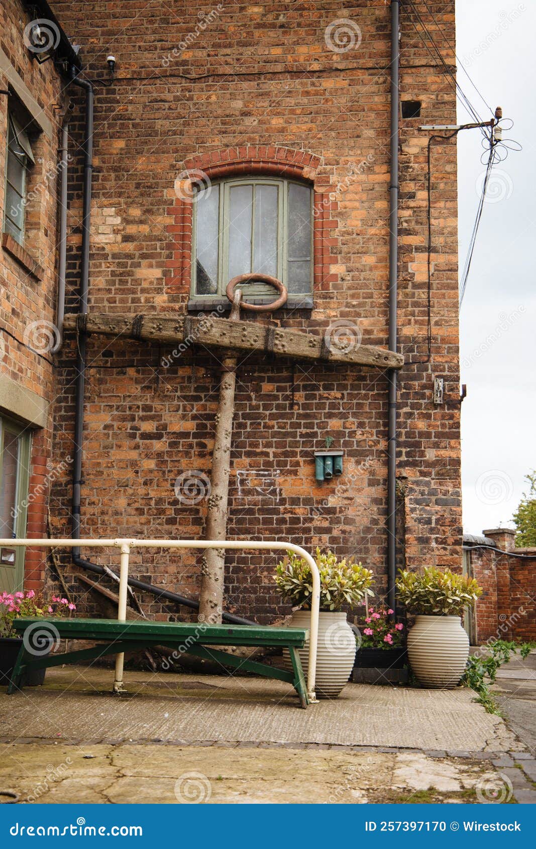 Vertical of an Anchor Leaned Against a Red Brick Wall at a Dockyard ...