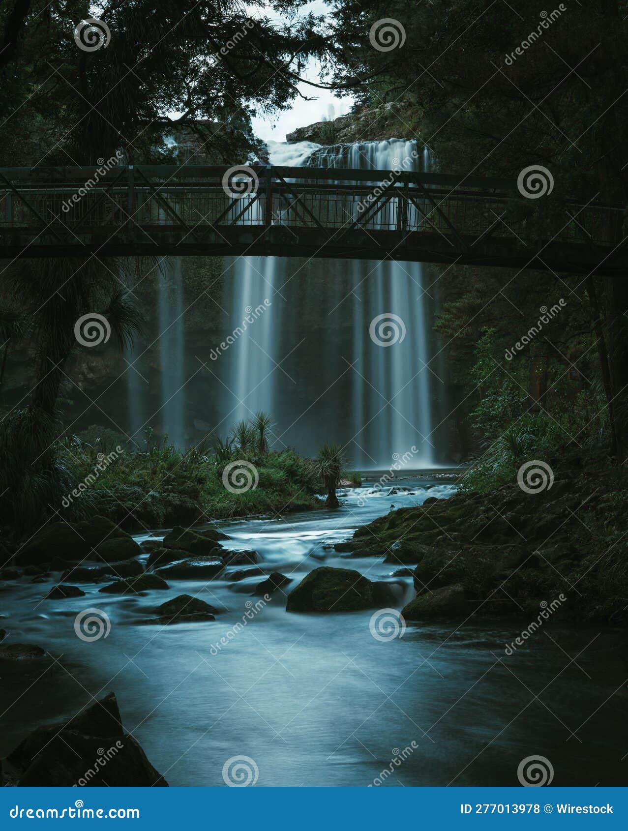 Vertical of a Bridge Overlooking a Powerful Waterfall Cascading into a ...