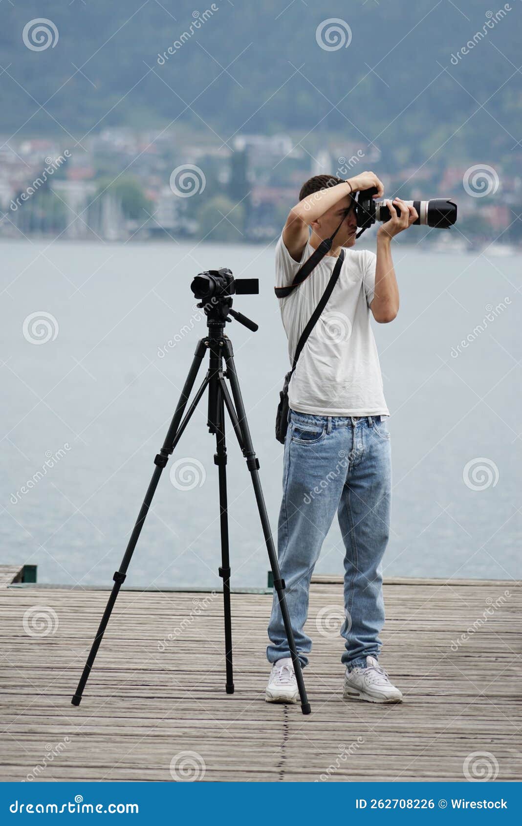 Vertical of a Caucasian Young Photographer with a Video Camera on the ...