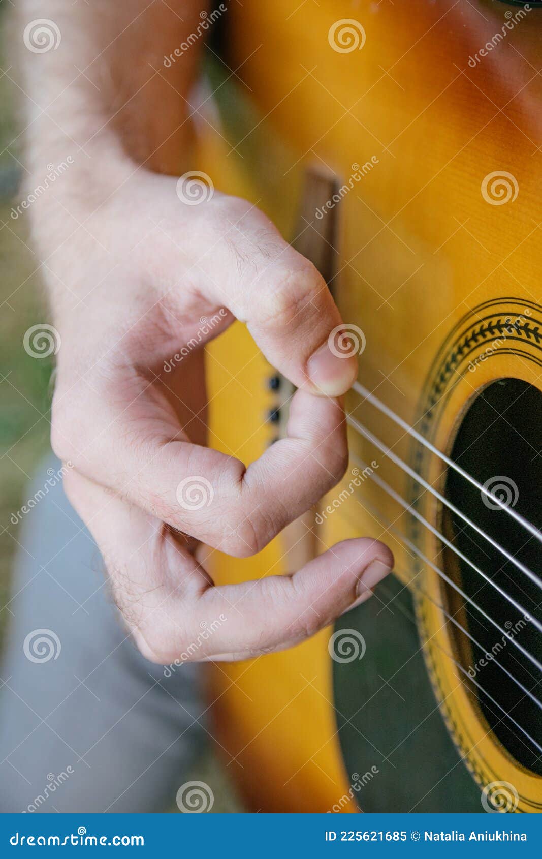 Vertical Close-up of a Guitar Playing with a Man`s Hand Playing the ...