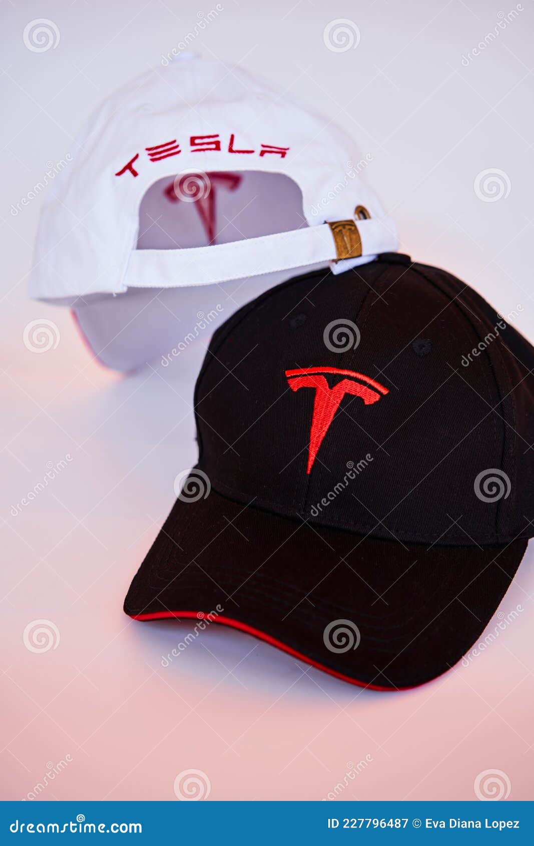 Vertical Close-up of Two Black and White Caps with Tesla Logotype in ...