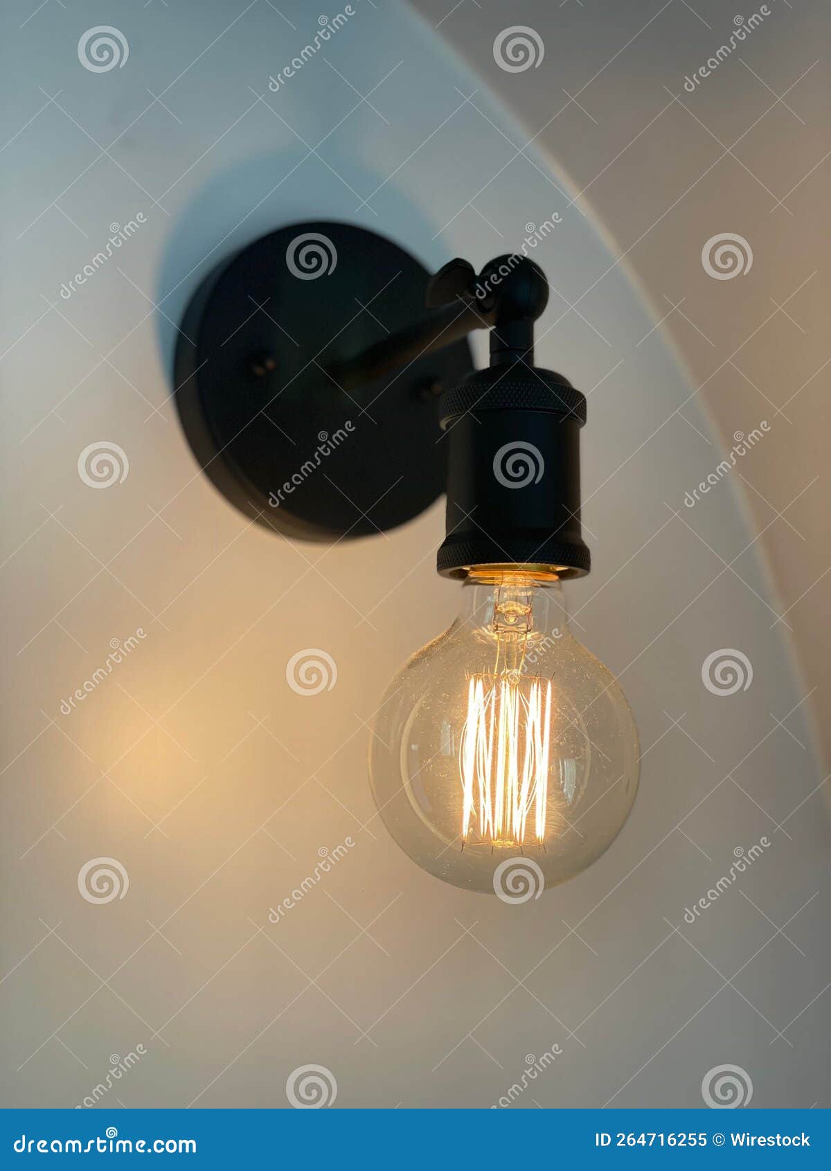 Vertical Closeup of a Light Bulb Hanging on a White Wall Stock Image ...