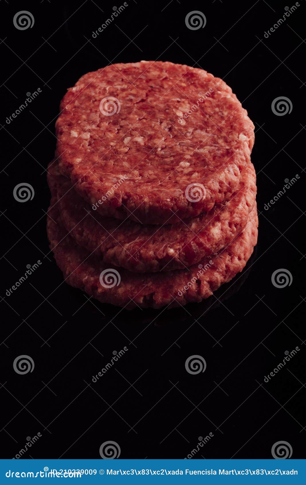 Vertical Closeup Shot of a Stack of Raw Burger Patties on a Black ...