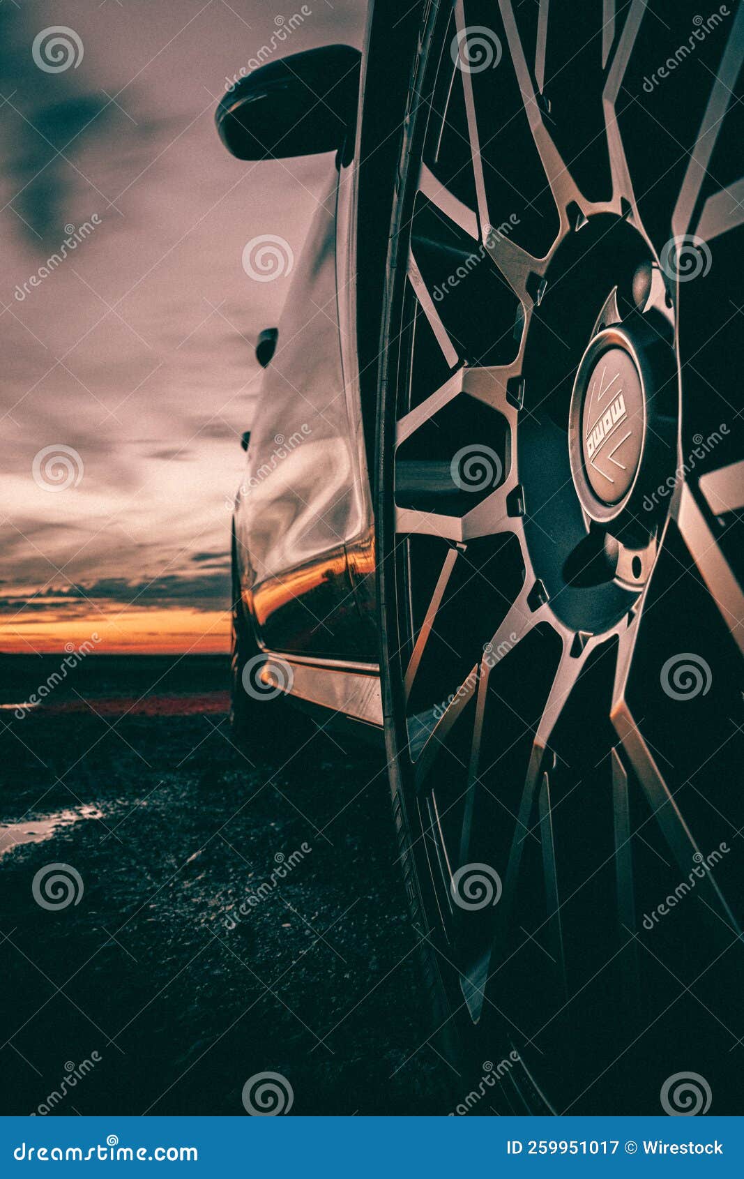 Vertical Closeup of the Wheel Rim of a Car with Sunset Reflection on it ...