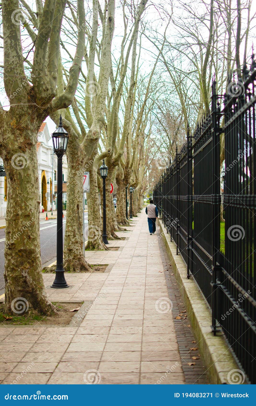 Vertical Distant Shot of a Man Walking Down the Sidewalk Stock Image ...