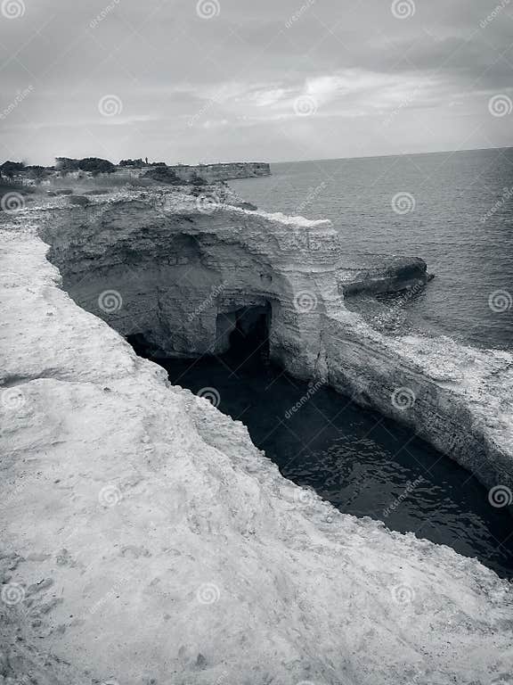 Vertical Grayscale Shot of Cliffs by the Sea Stock Photo - Image of ...