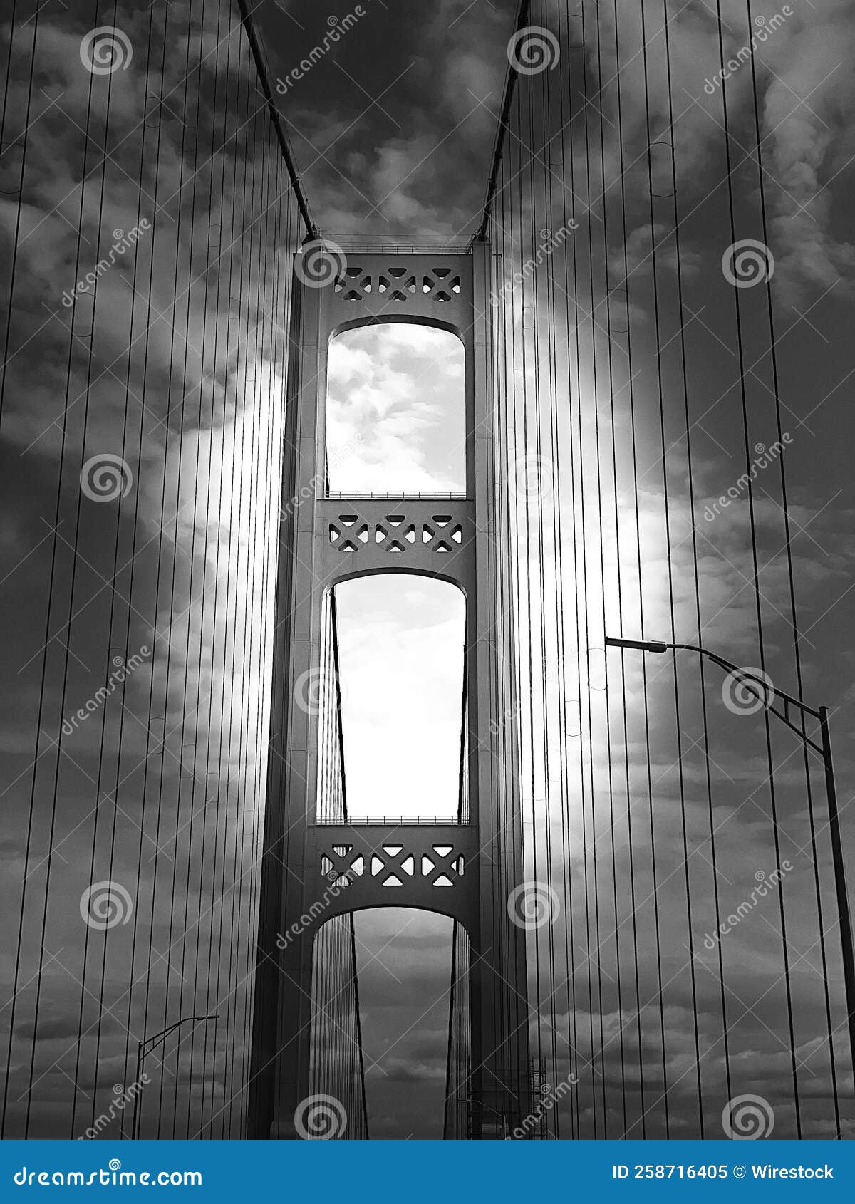 Vertical Grayscale Shot of a Suspension Bridge with Clouds in the ...