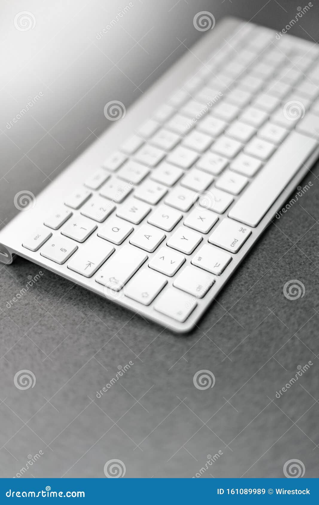Vertical Greyscale Closeup Shot of a White Keyboard on a Grey Surface ...