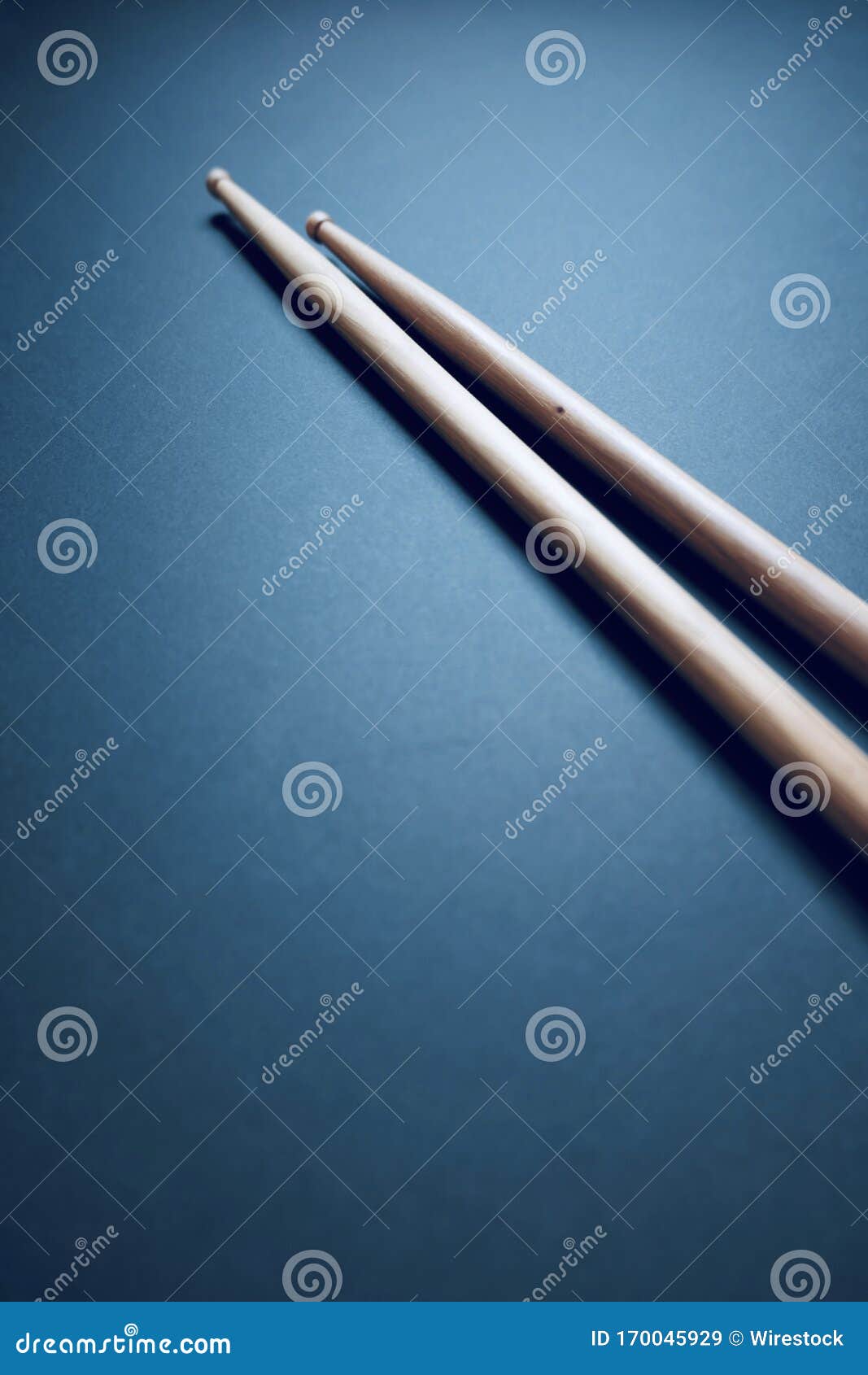 Vertical High Angle Shot of Two Drumsticks on a Blue Surface Stock ...