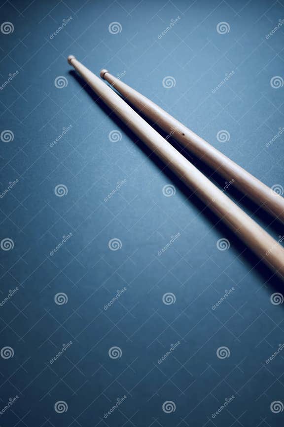 Vertical High Angle Shot of Two Drumsticks on a Blue Surface Stock ...