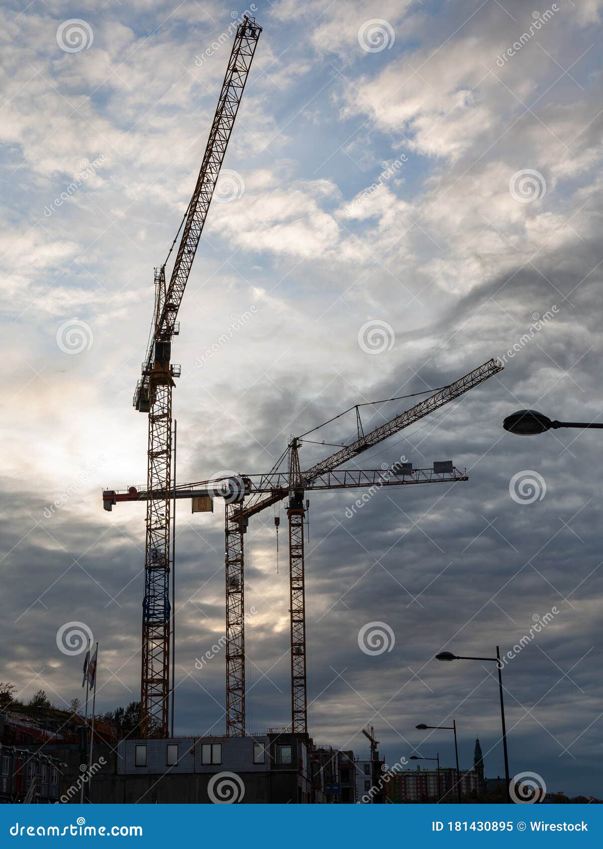 Vertical Image Of Cranes In A Construction Site Against A Cloudy ...