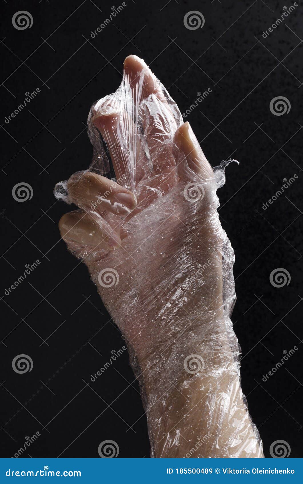 Vertical Image.Human Hand in the Plastic Sheeting and Water Drops on it ...