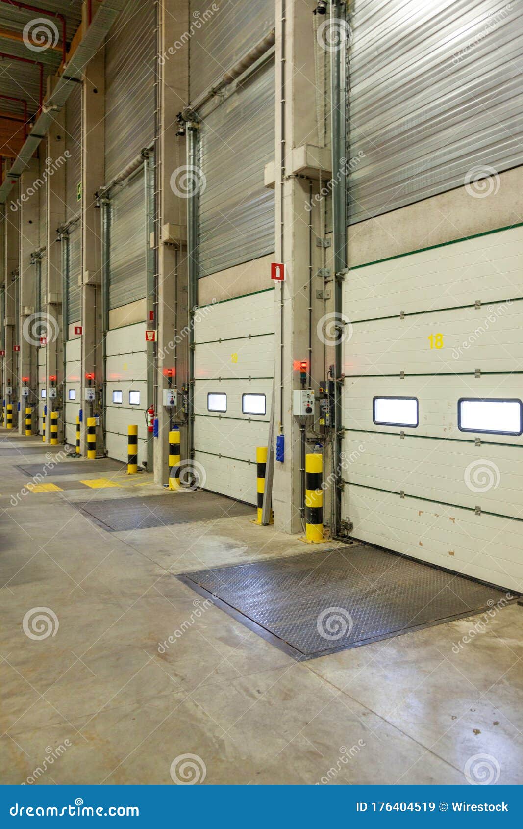 Vertical Interior Shot of a Warehouse with a Row of Doors and Control ...
