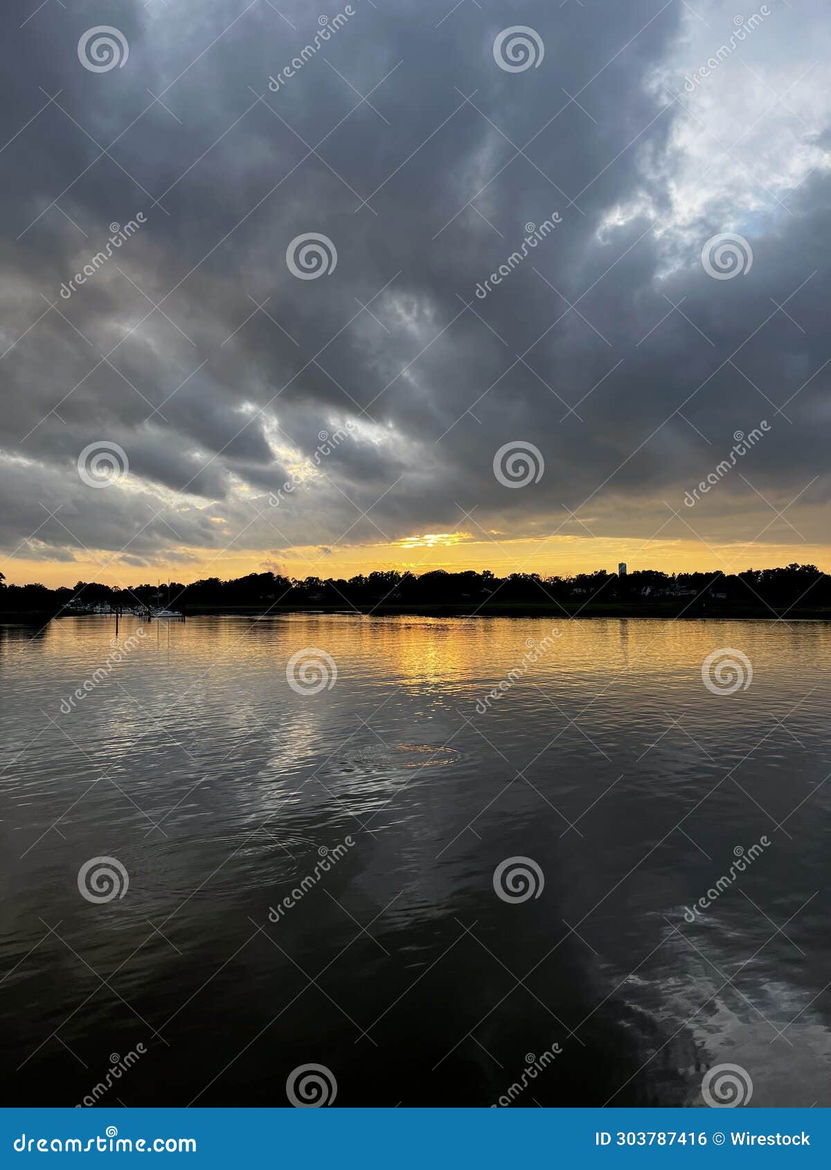 Vertical of a Lake Reflecting Sunset on a Cloudy Day Stock Photo ...