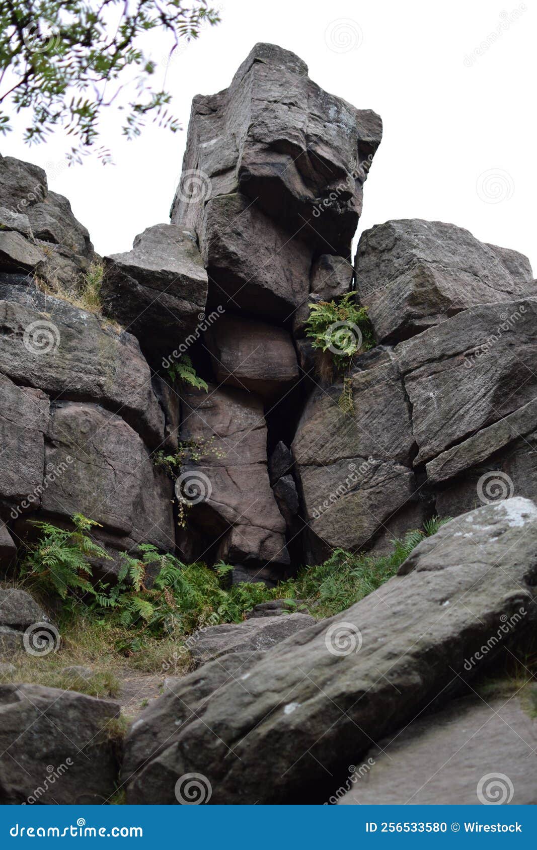 Vertical Low-angle Shot of a Hanging Stone with Sky in the Background ...