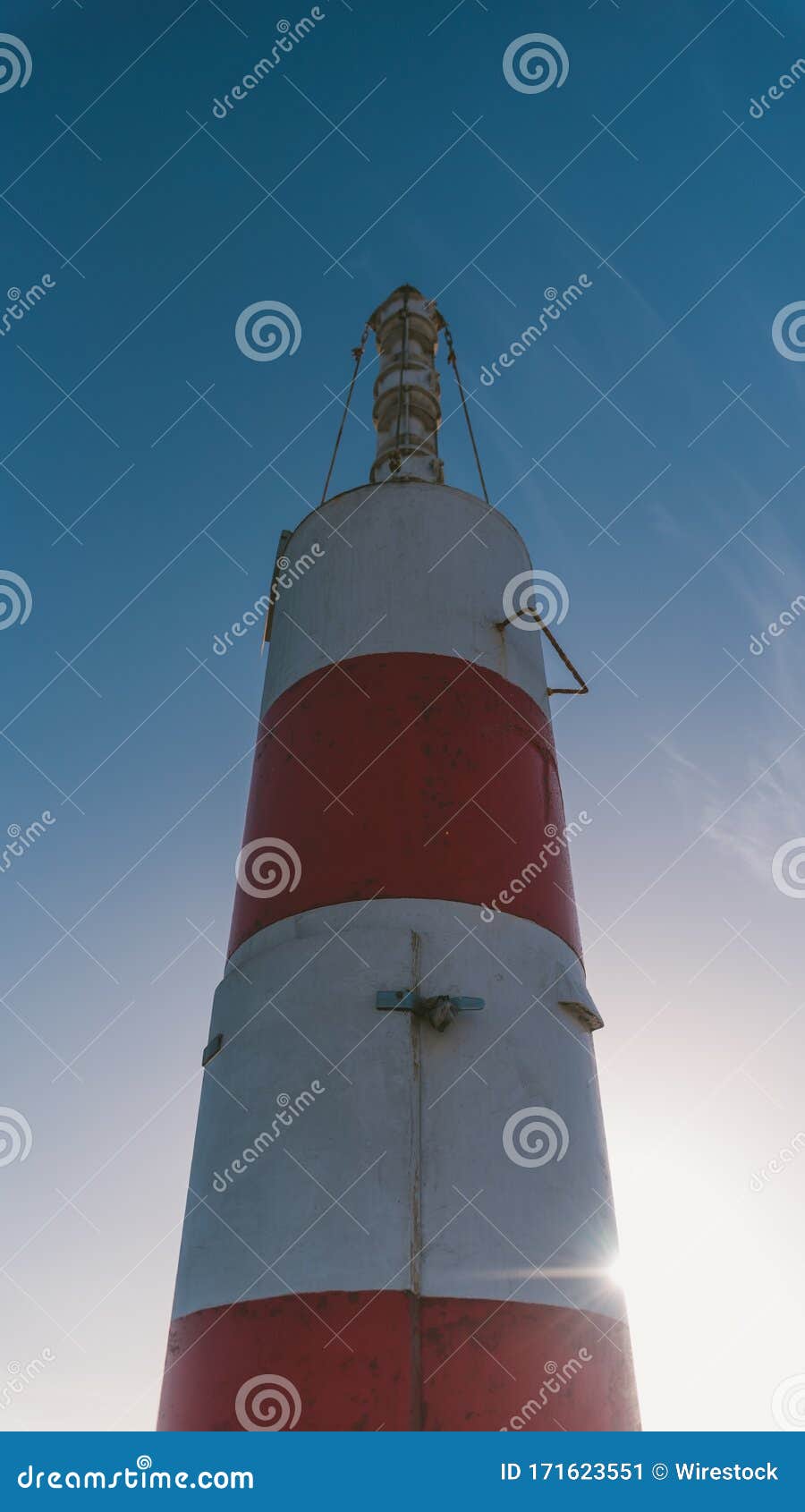 Vertical Low Angle Shot of a Red and White Lighthouse Under the ...