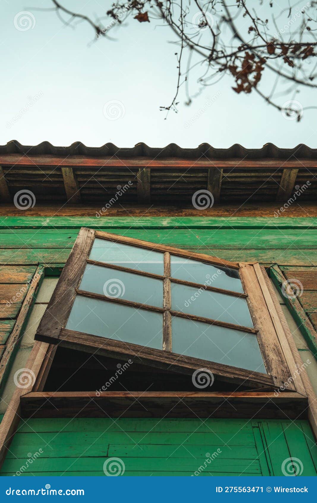 Vertical Low Angle Shot of a Wooden Window Opening on a Green Wall ...