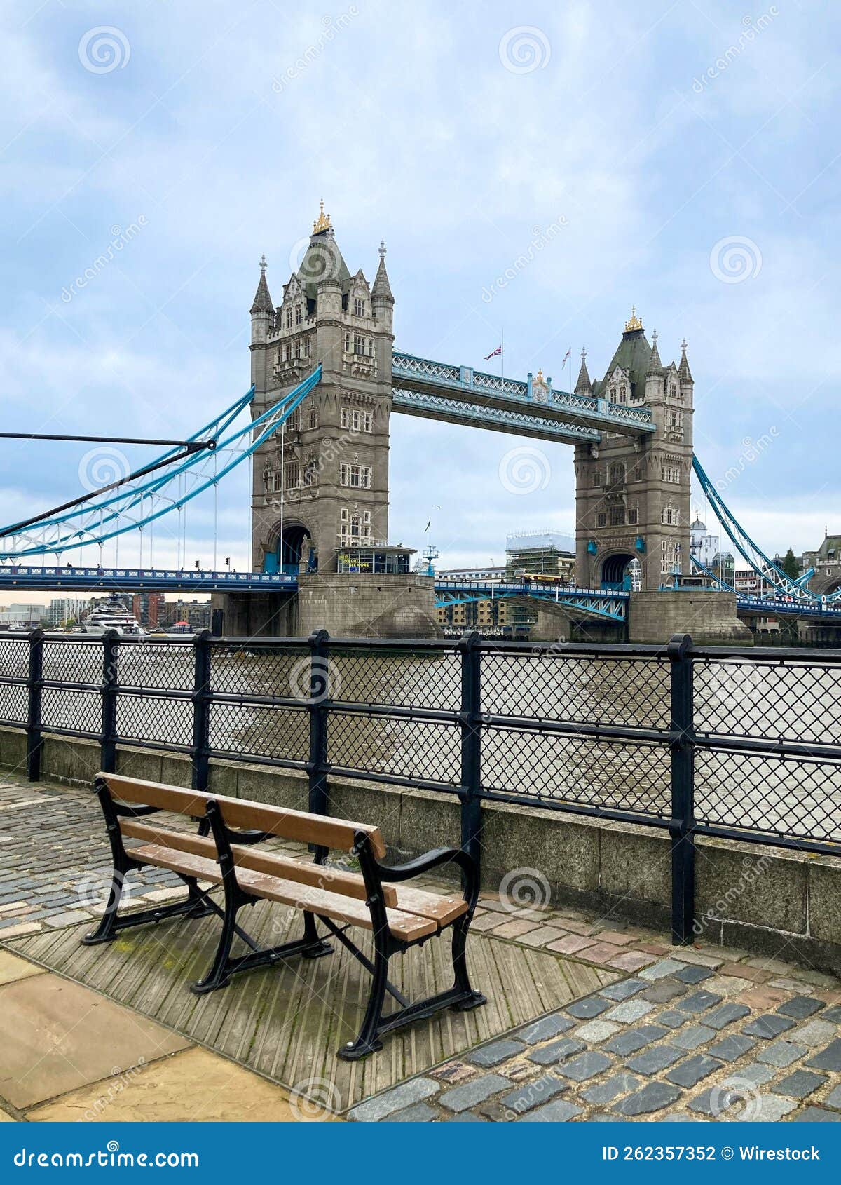 Vertical Low-angle of Tower Bridge from a Platform with a Bench Cloudy ...